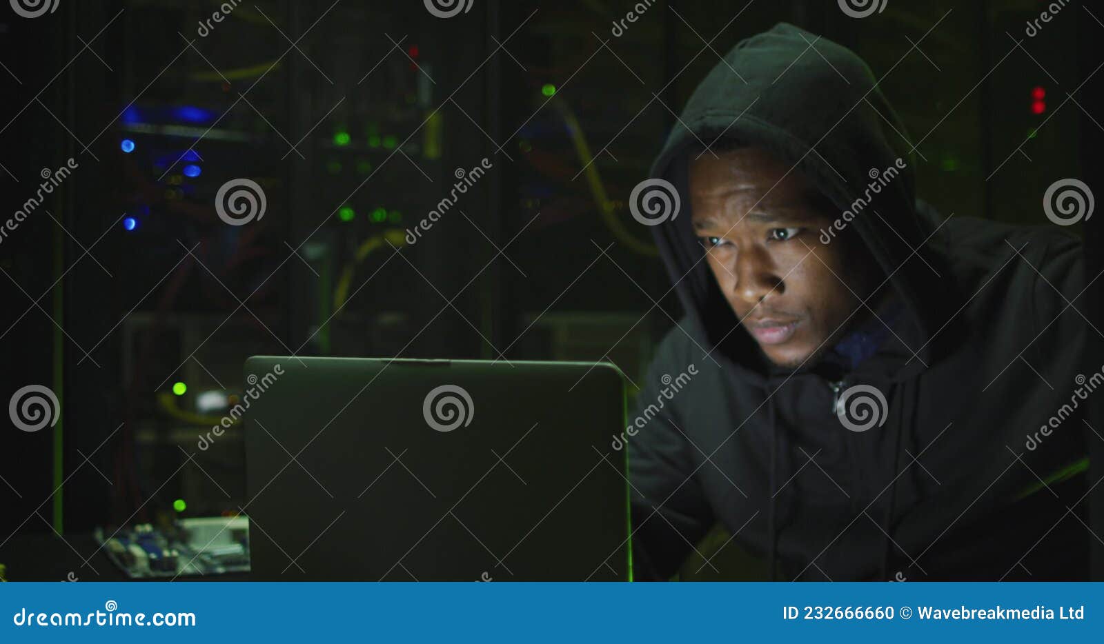 African American Male Computer Hacker Using Laptop in Business Server ...