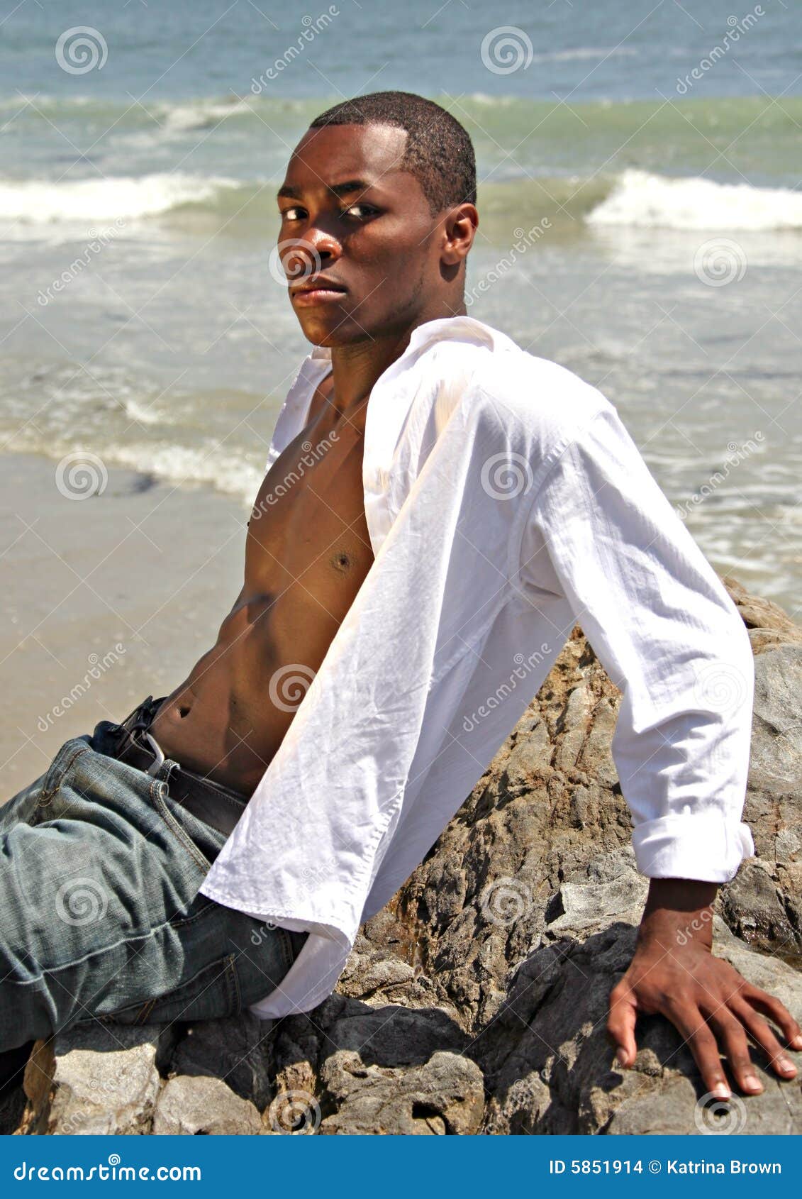African American Male Posing on Rocks at the Beach Stock Photo - Image ...
