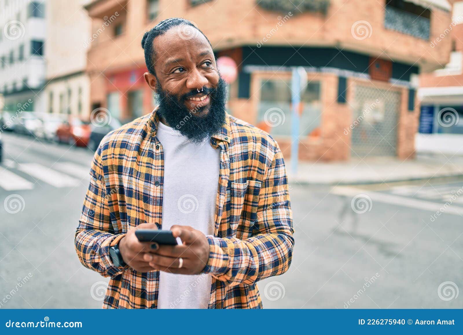 African American Man With Beard Using Smartphone Typing And Texting At