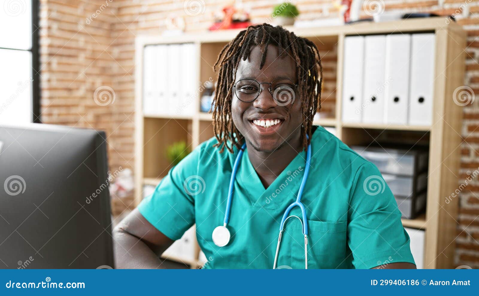 African American Man Doctor Using Computer Smiling at the Clinic Stock ...