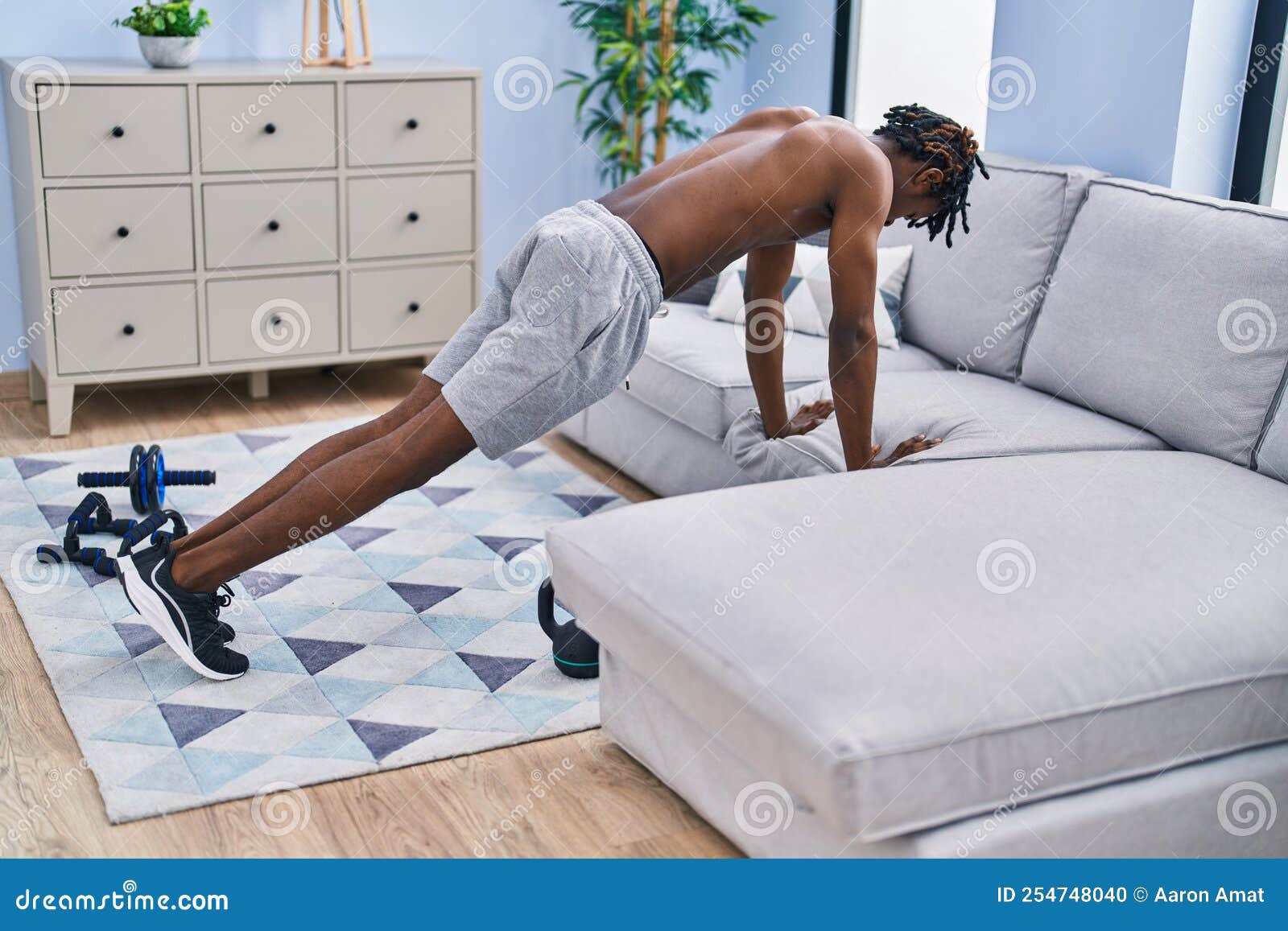 African American Man Training Push Up on Sofa at Home Stock Photo ...