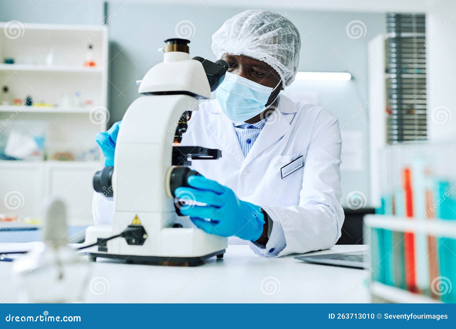 African American Man Using Microscope Doing Research in Laboratory ...