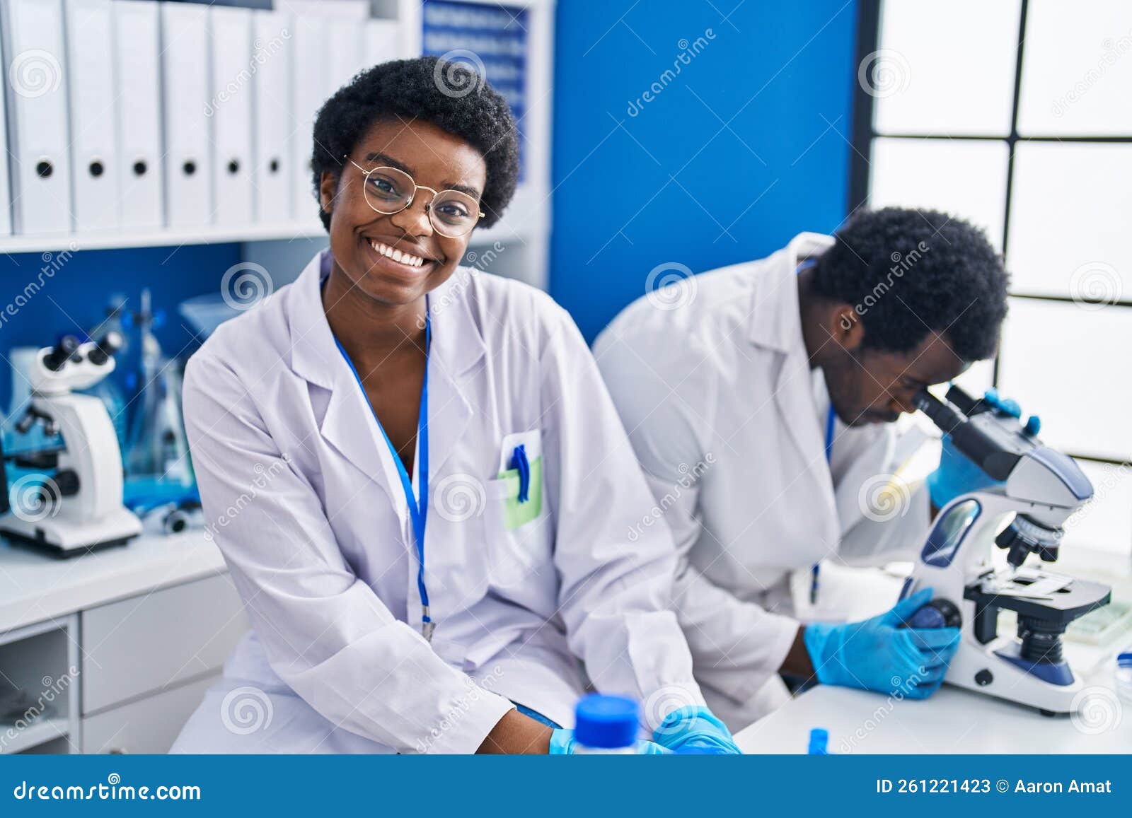 African American Man and Woman Scientists Using Microscope at ...