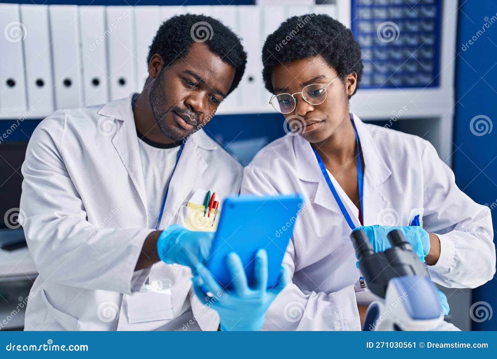 African American Man and Woman Scientists Using Touchpad Working at ...
