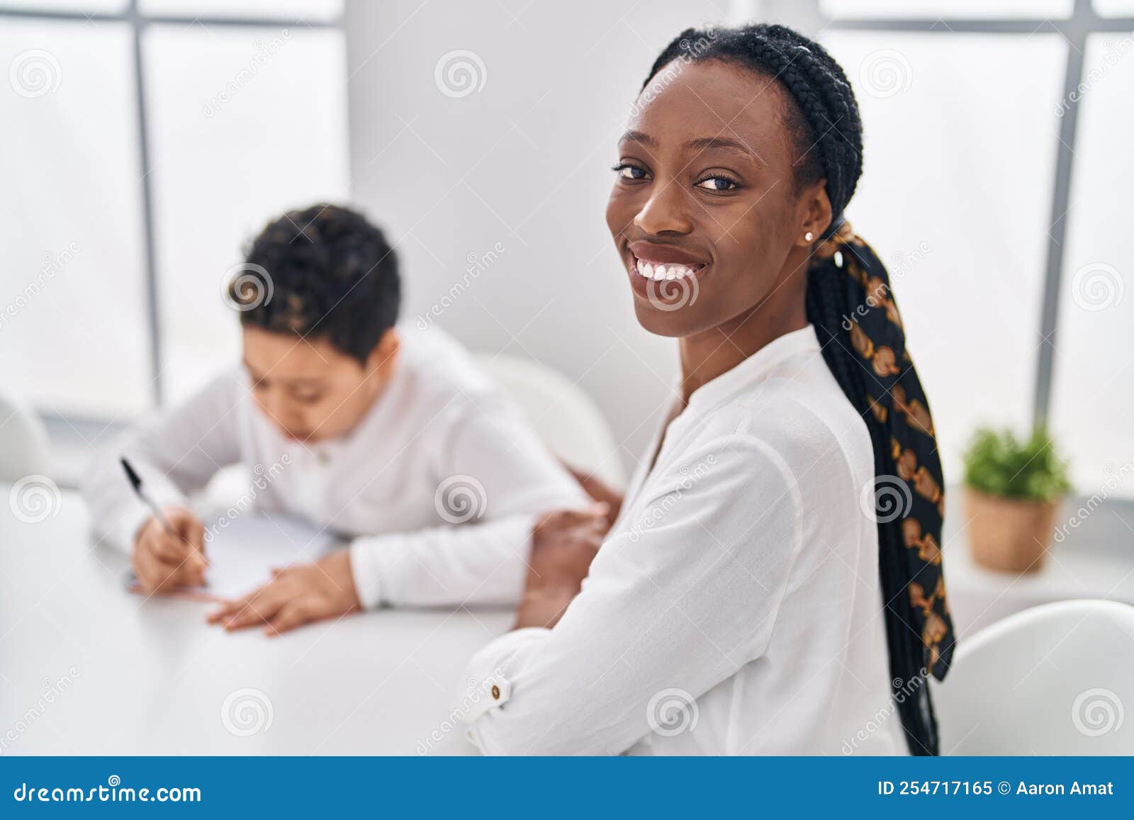 African American Mother and Son Writing on Notebook Sitting on Table at ...