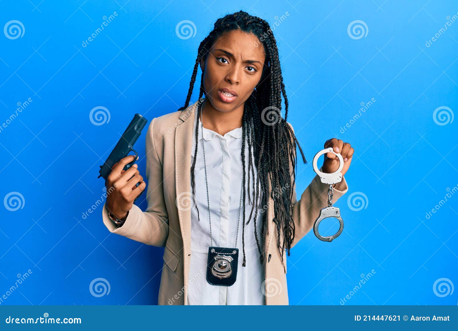 African American Police Woman Holding Gun And Handcuffs In Shock Face