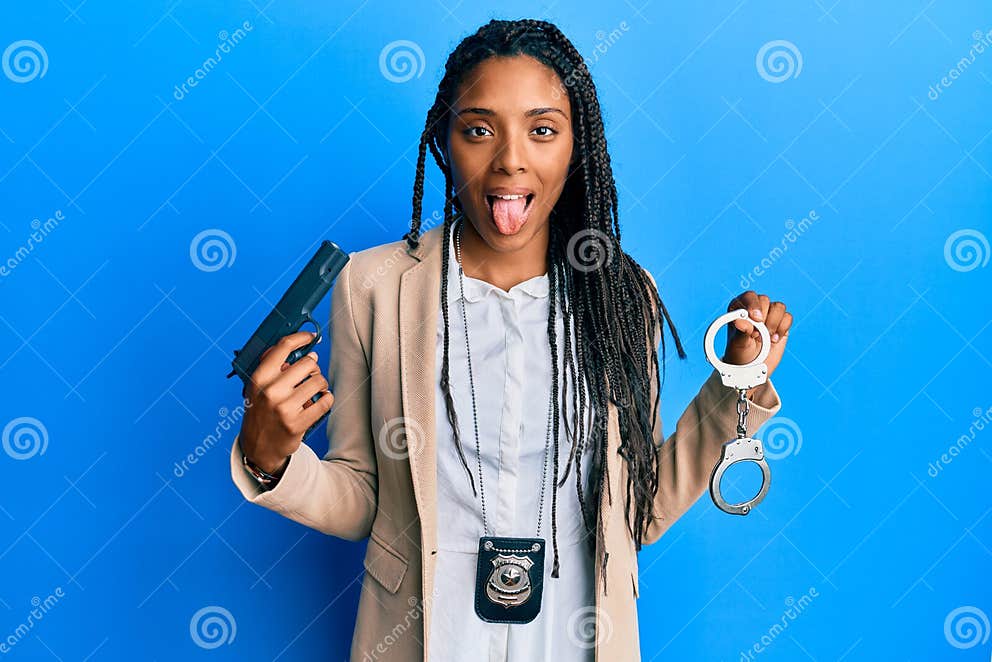 African American Police Woman Holding Gun And Handcuffs Sticking Tongue