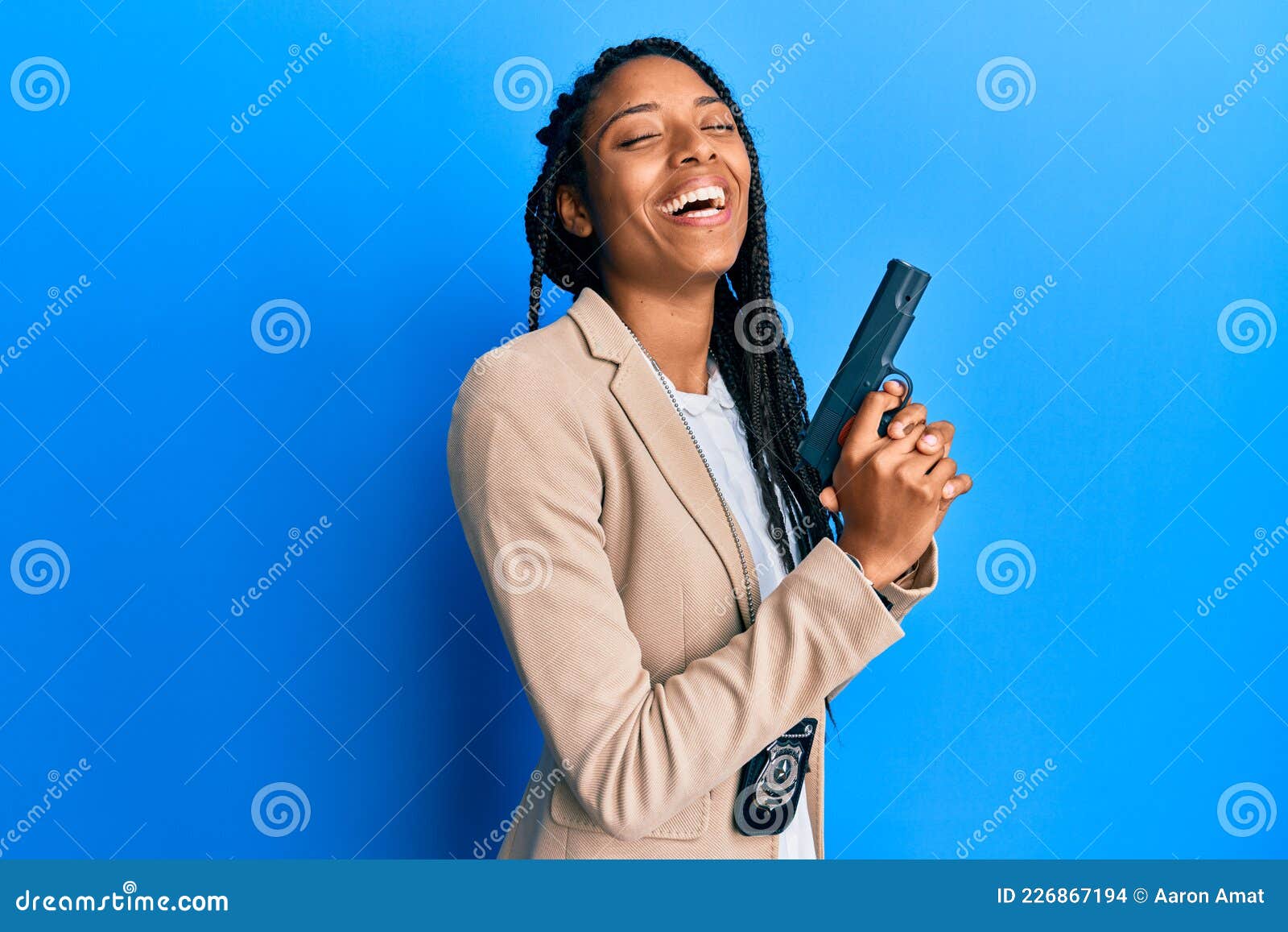 African American Police Woman Holding Gun Smiling And Laughing Hard Out