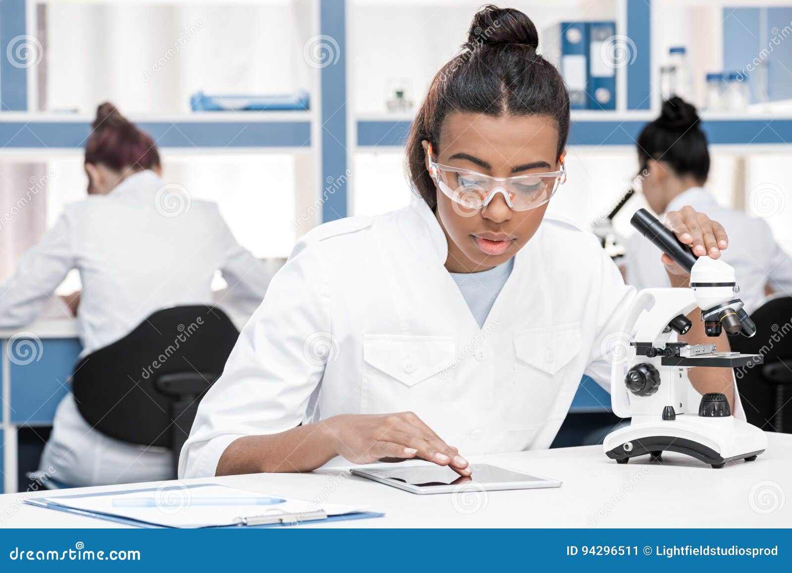 African American Scientist in Lab Coat with Microscope and Digital ...