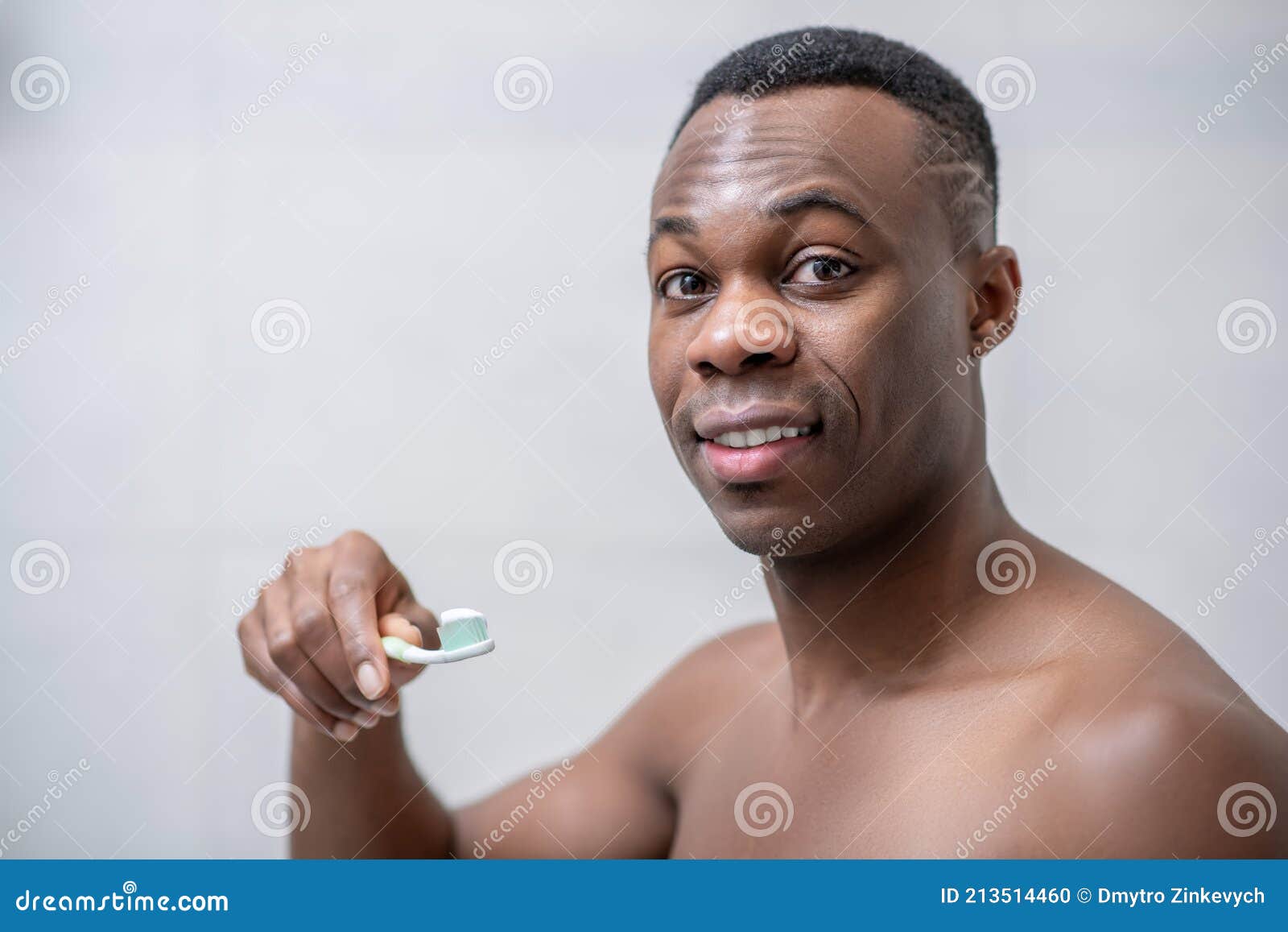 African American Short Haired Guy Looking At Himself In The Mirror