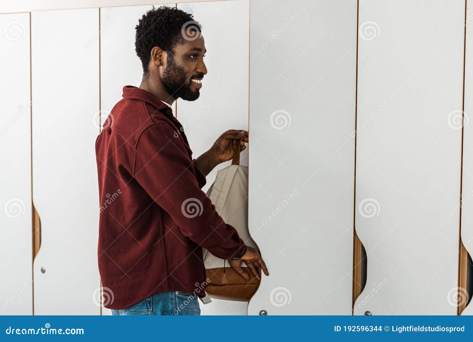 African American Student Putting Backpack in Locker Stock Photo - Image ...