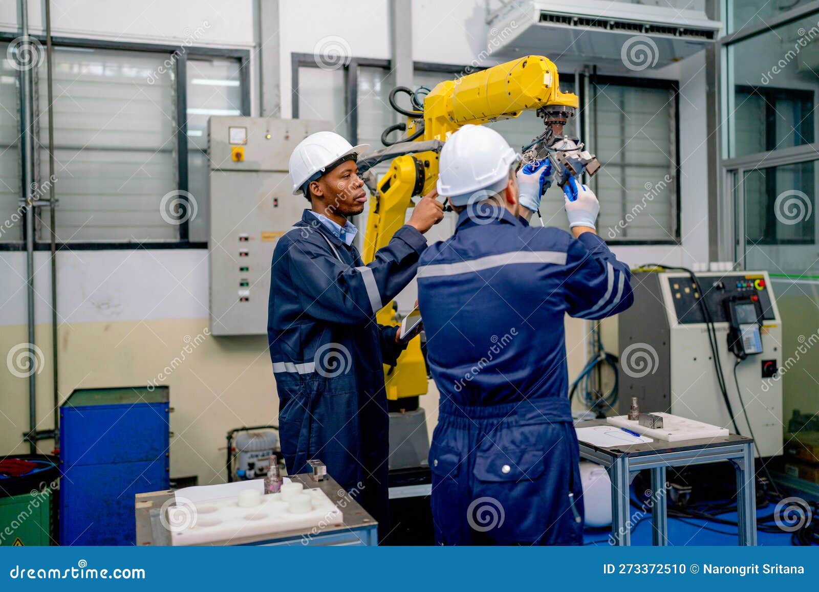 African American Technician or Engineer Point To Robotic Arm and Guide ...