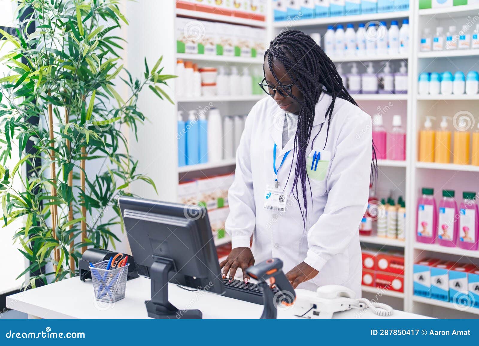 African American Woman Pharmacist Smiling Confident Using Computer at ...