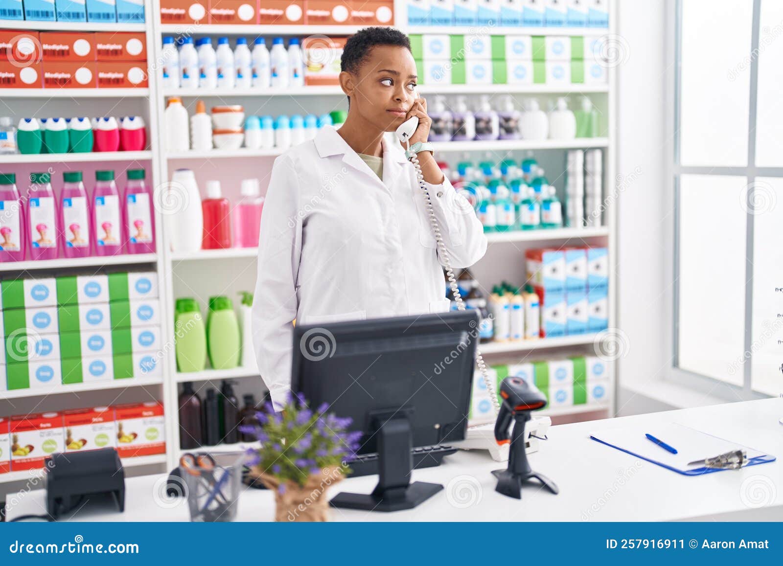 African American Woman Pharmacist Talking on Telephone Using Computer ...