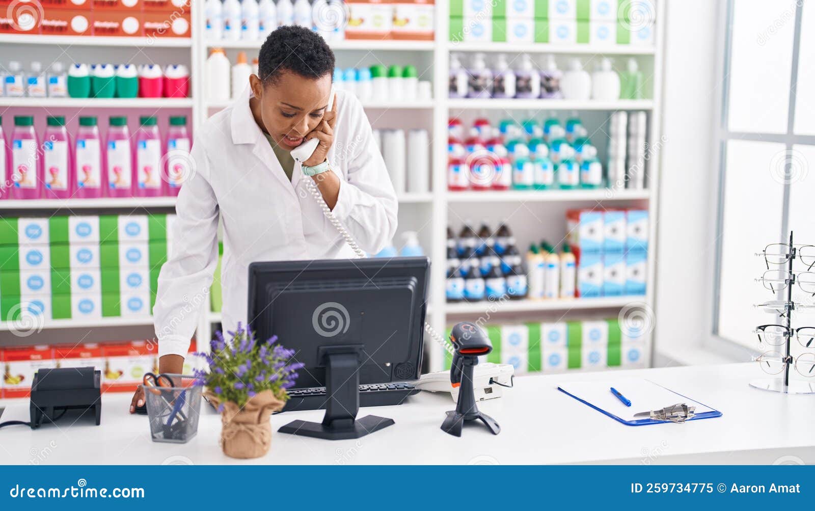 African American Woman Pharmacist Talking on Telephone Using Computer ...