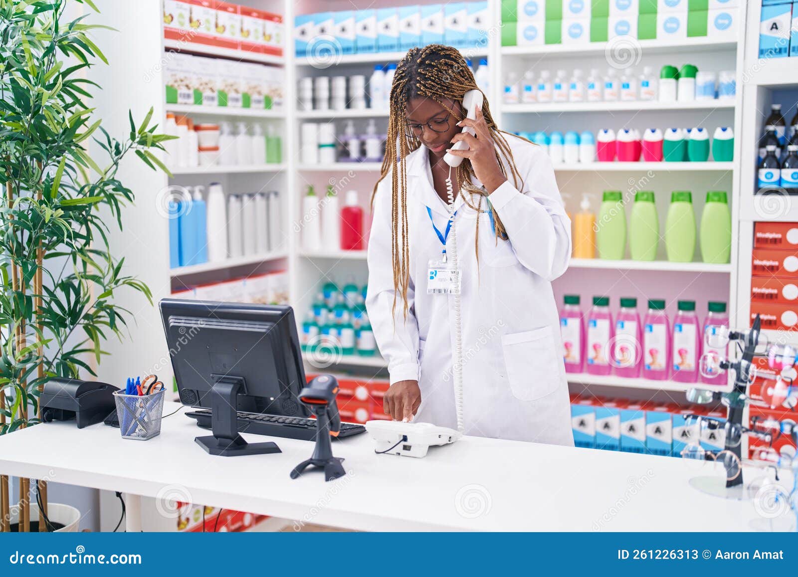 African American Woman Pharmacist Talking on Telephone Using Computer ...