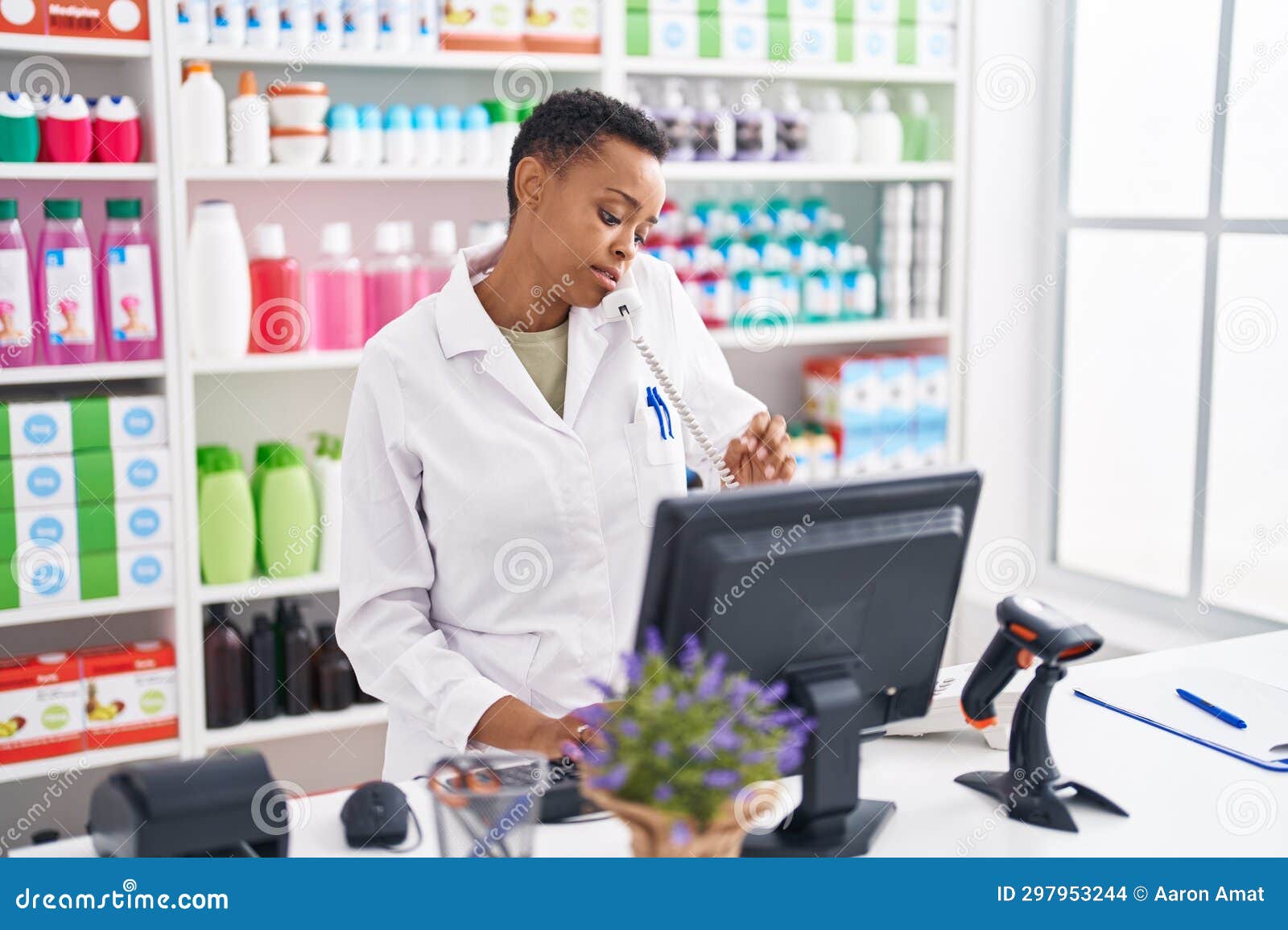 African American Woman Pharmacist Talking on Telephone Using Computer ...