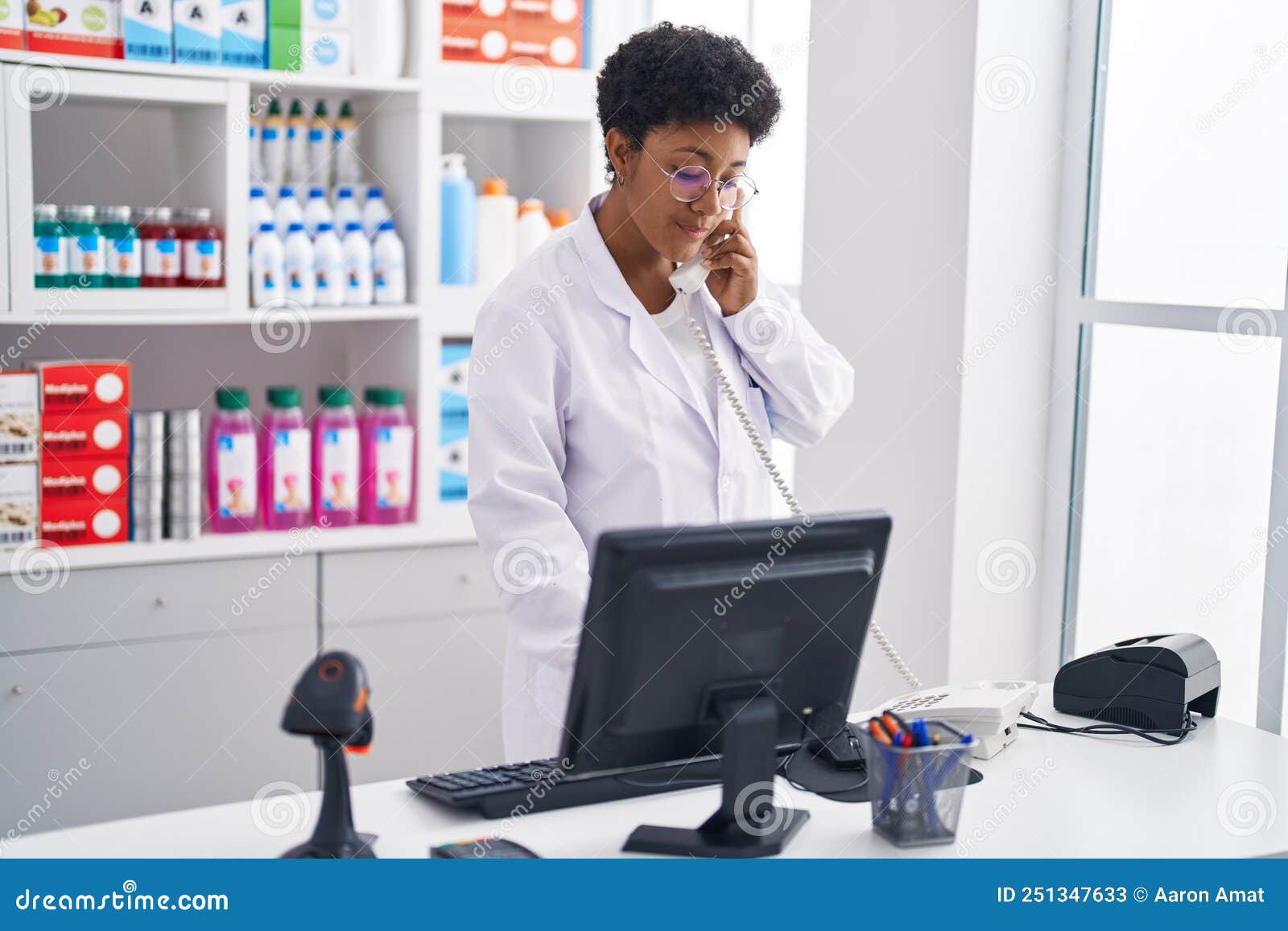 African American Woman Pharmacist Using Computer Talking on Telephone ...