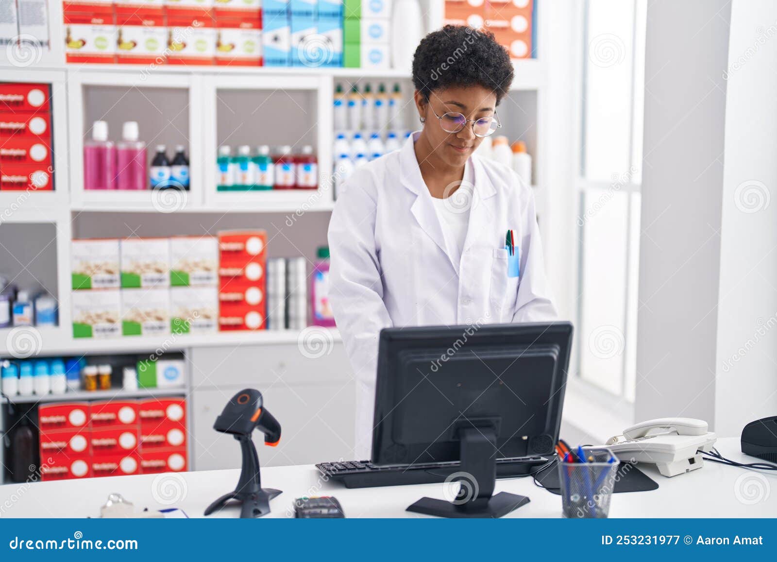 African American Woman Pharmacist Using Computer Working at Pharmacy ...