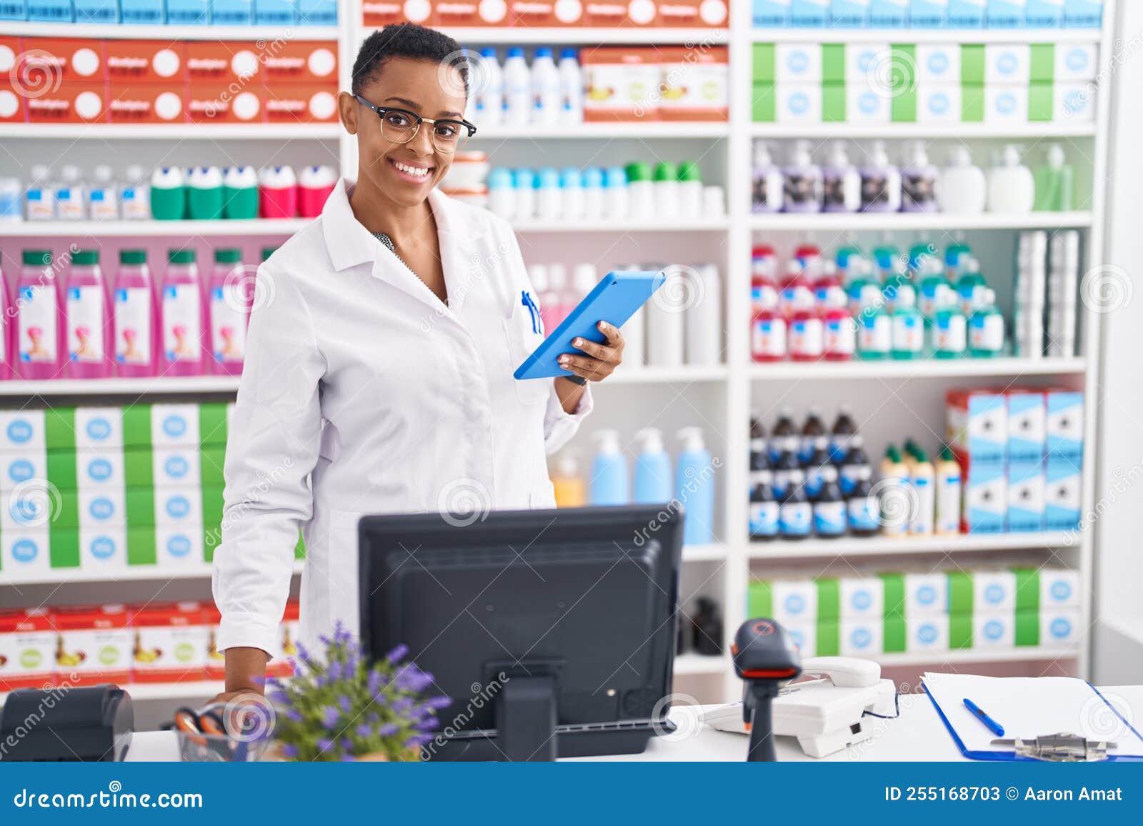 African American Woman Pharmacist Using Touchpad and Computer at ...