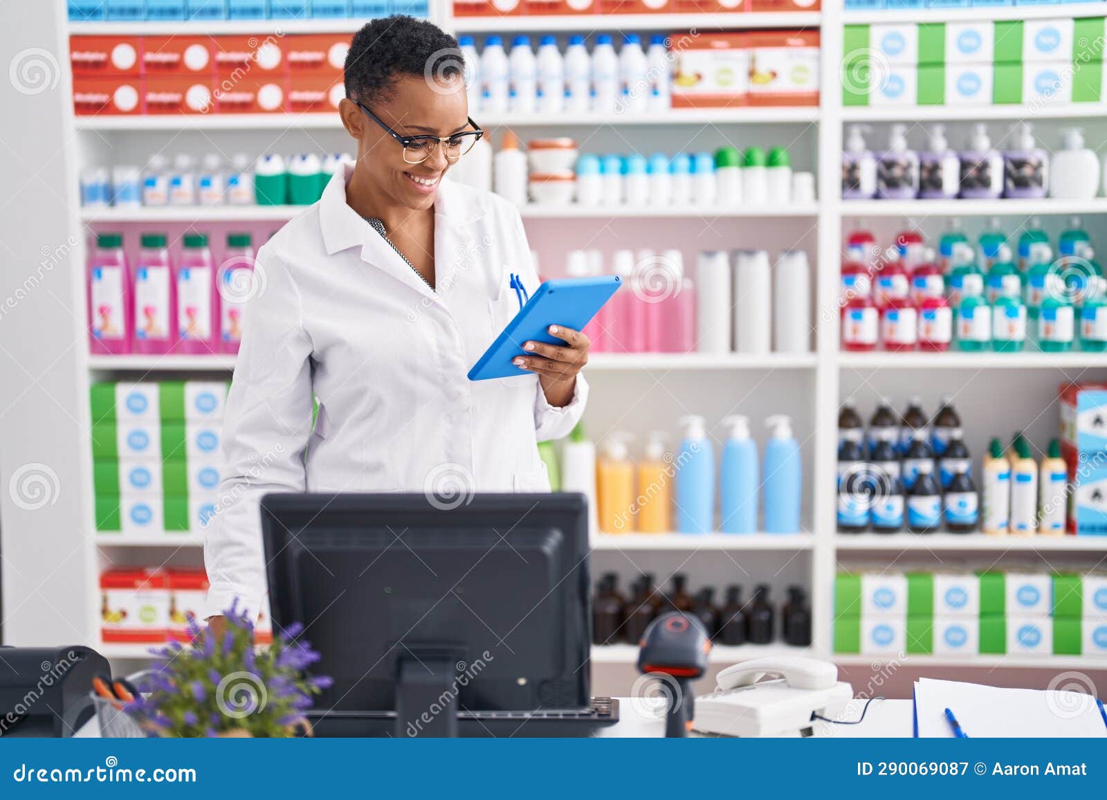 African American Woman Pharmacist Using Touchpad and Computer at ...
