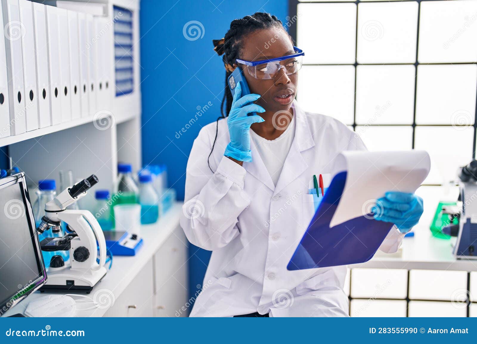 African American Woman Scientist Reading Document at Laboratory Stock ...