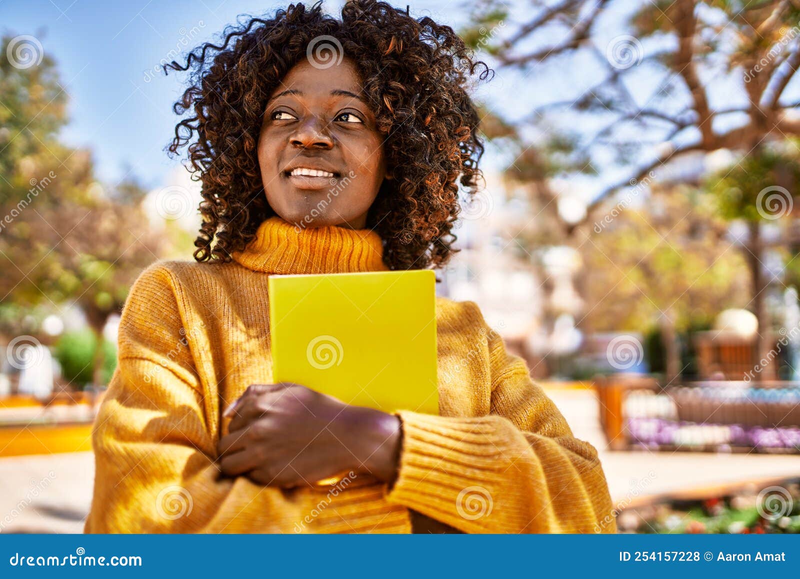 African American Woman Smiling Confident Holding Book at Park Stock ... African American Woman Smiling Confident Holding Book at Park Stock ...