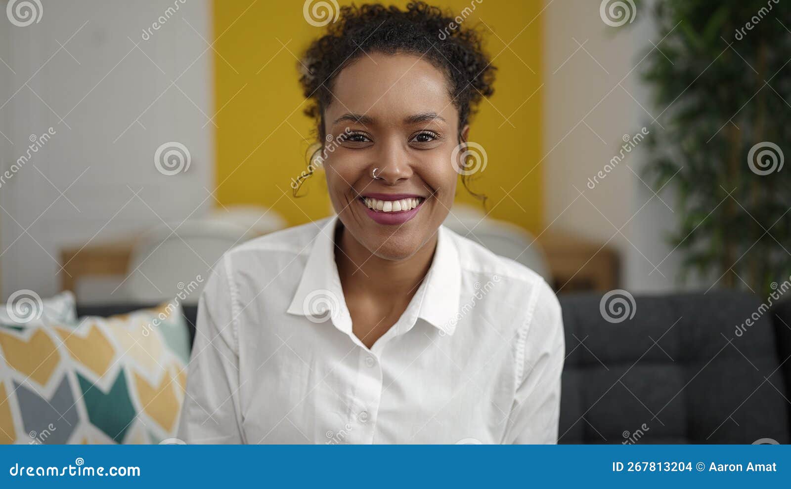 African American Woman Smiling Confident Sitting On Sofa At Home Stock