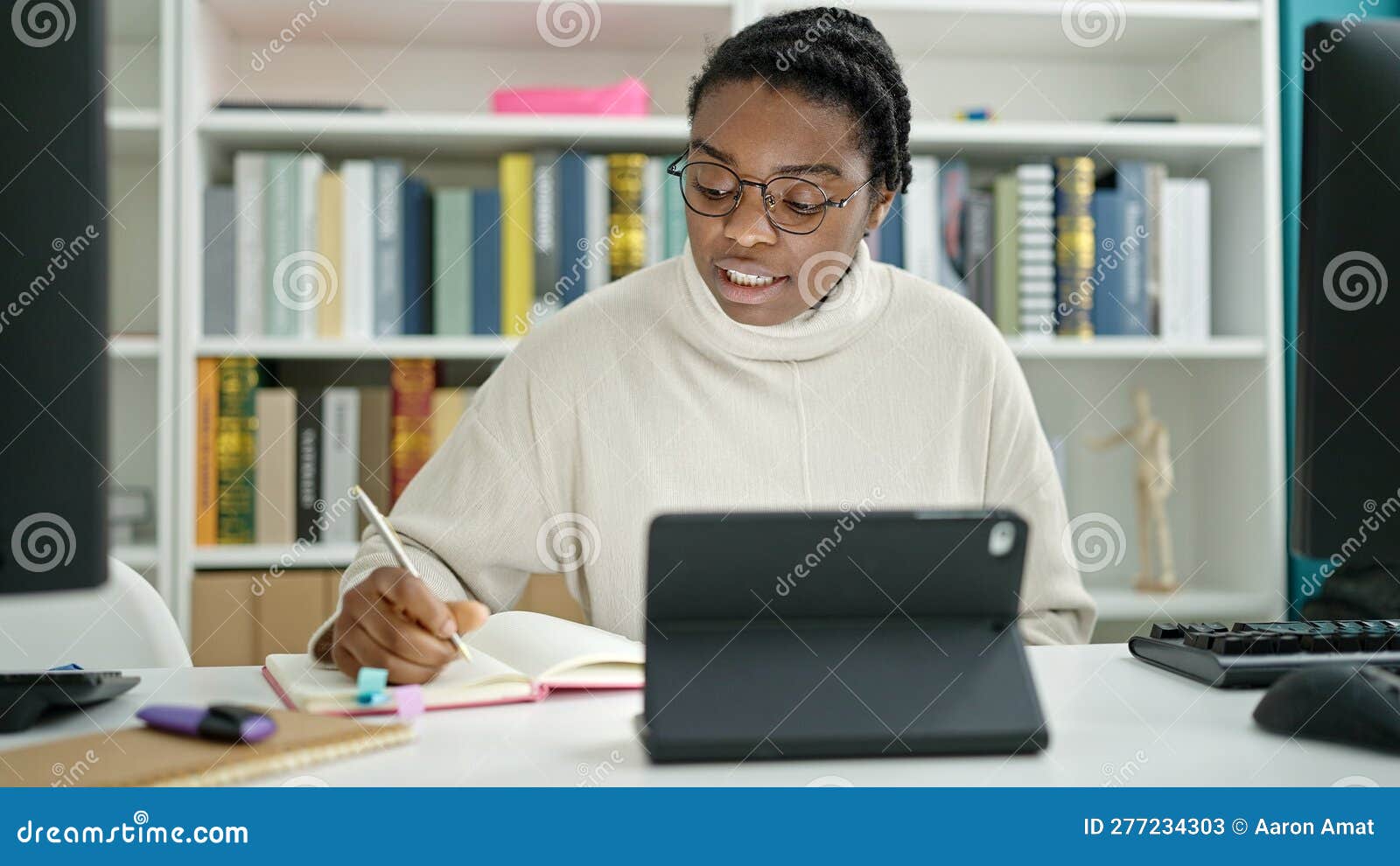 African American Woman Student Using Touchpad Writing Notes at Library ...