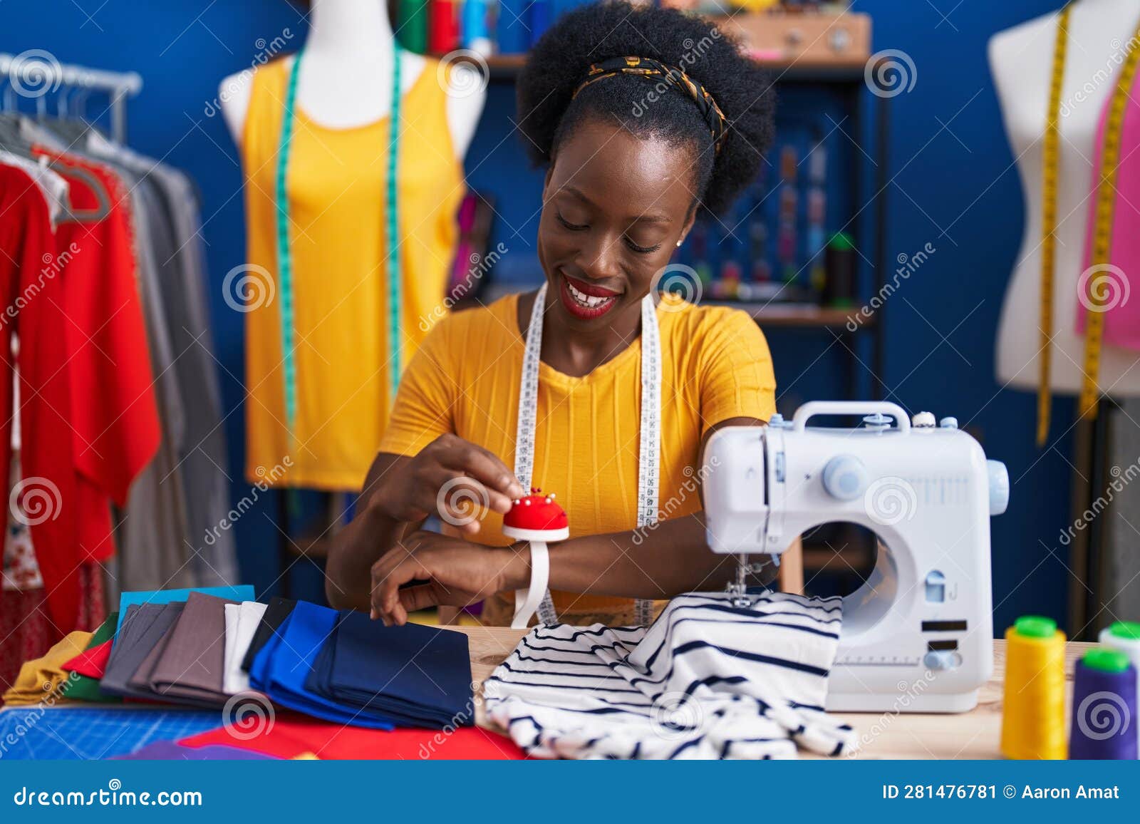 African American Woman Tailor Using Sewing Machine Holding Pin at ...
