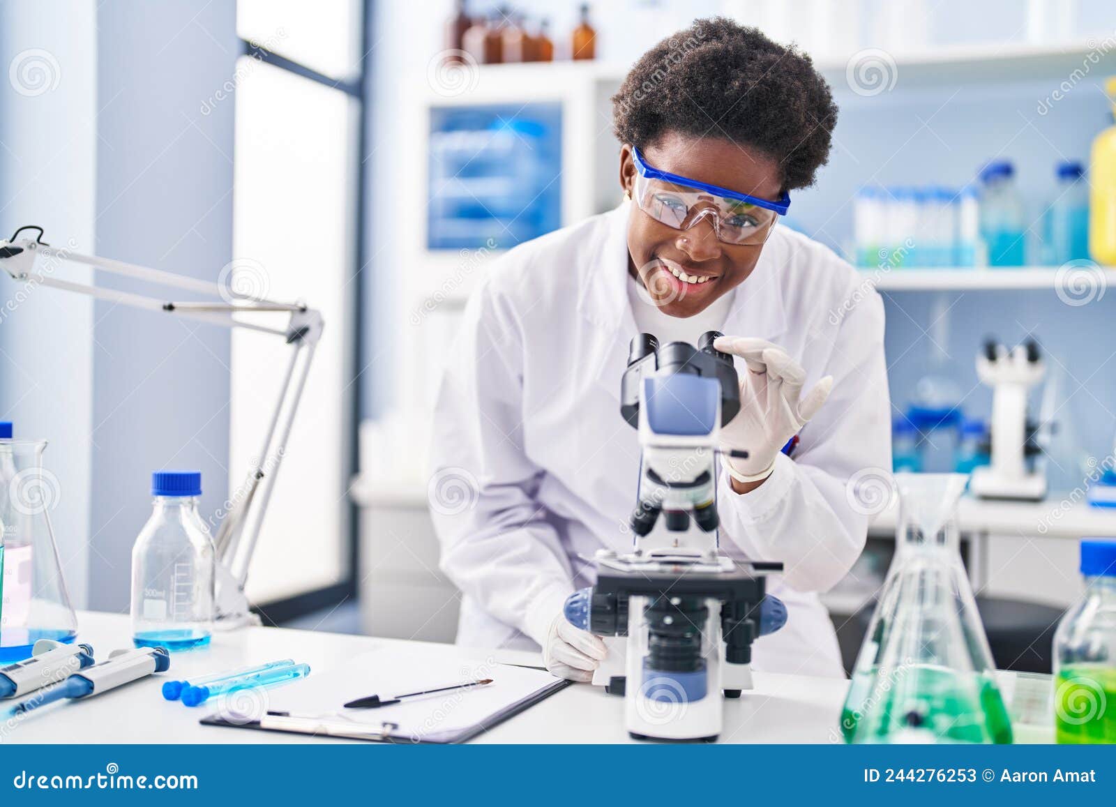 African American Woman Wearing Scientist Uniform Using Microscope at ...