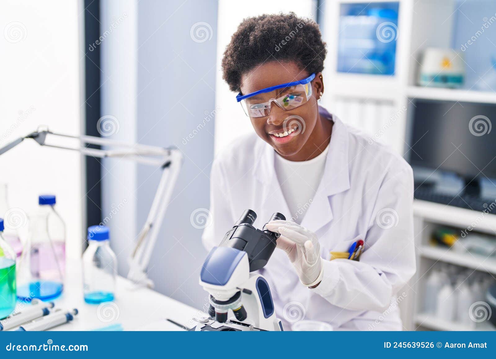 African American Woman Wearing Scientist Uniform Using Microscope at ...