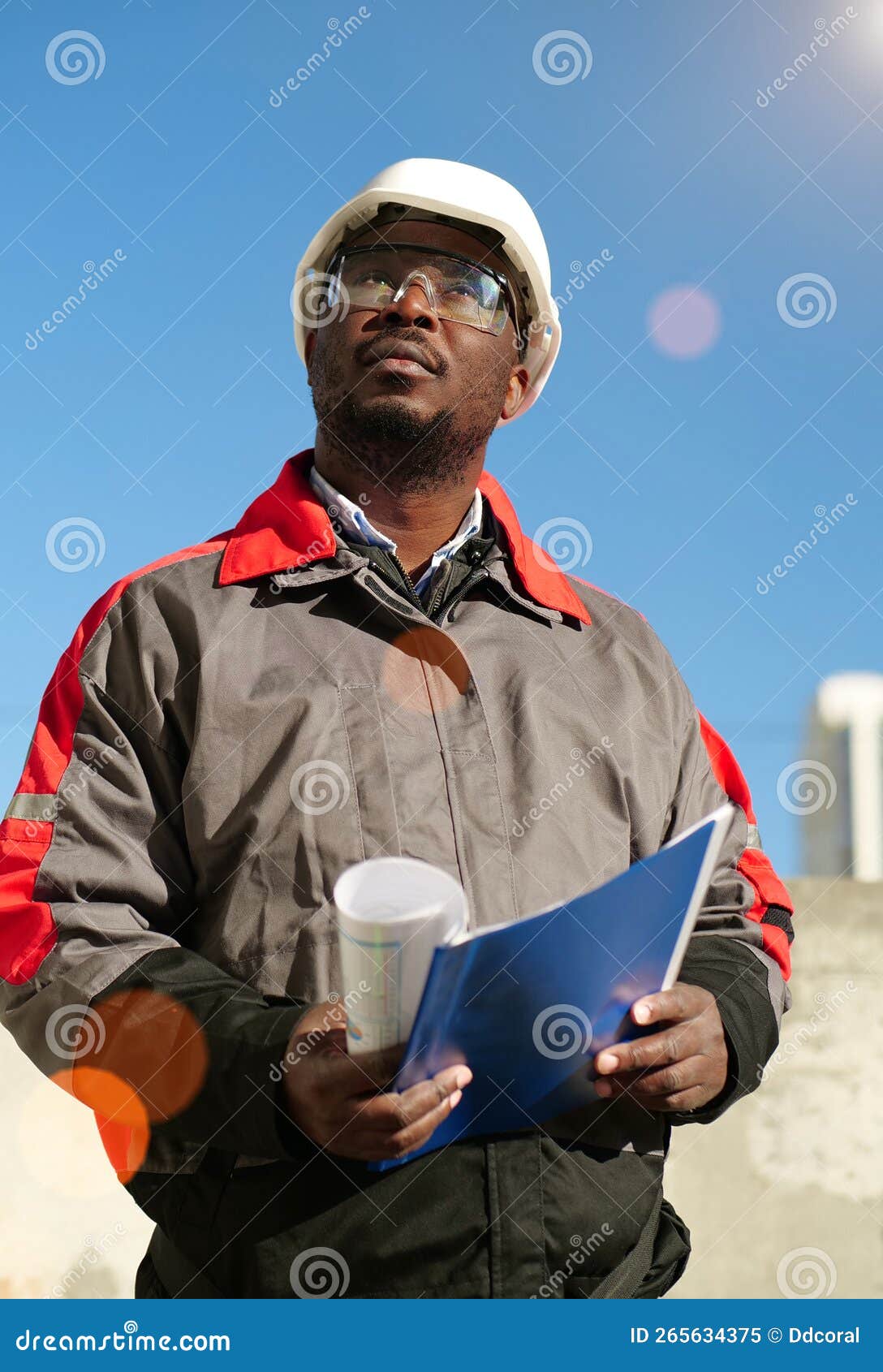 African American Worker Stands at Construction Site, Holds in Hands ...