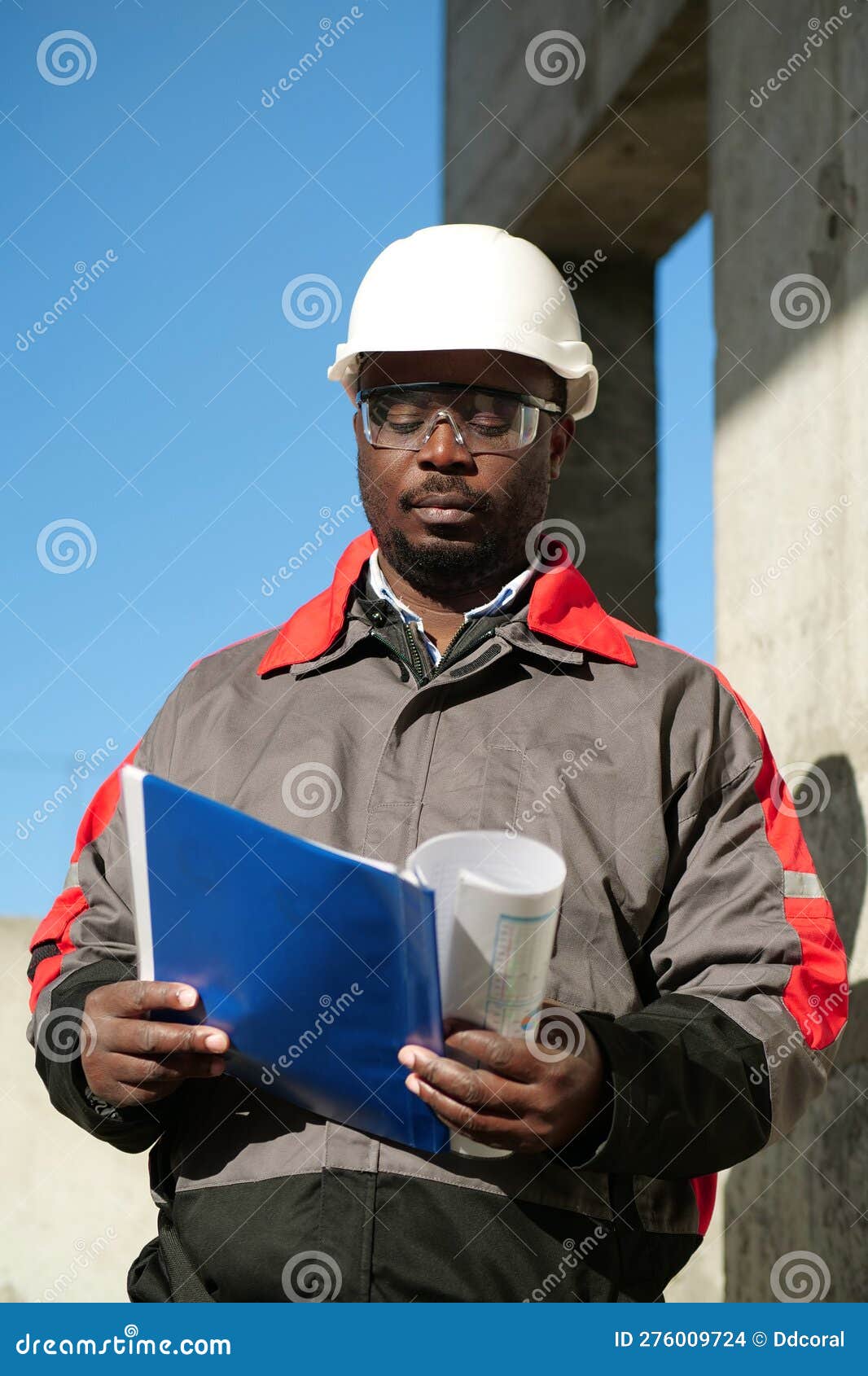 African American Worker Stands at Construction Site with Work Papers ...