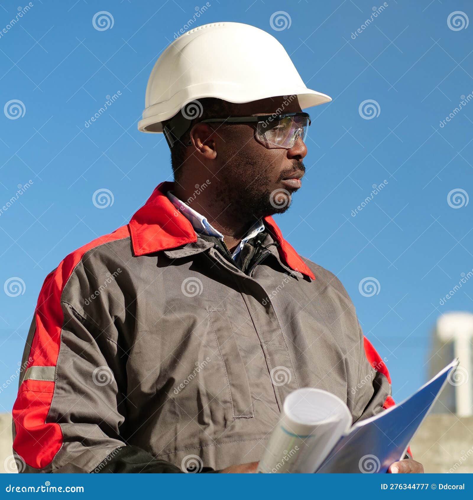 African American Worker Stands at Construction Site with Work Papers ...