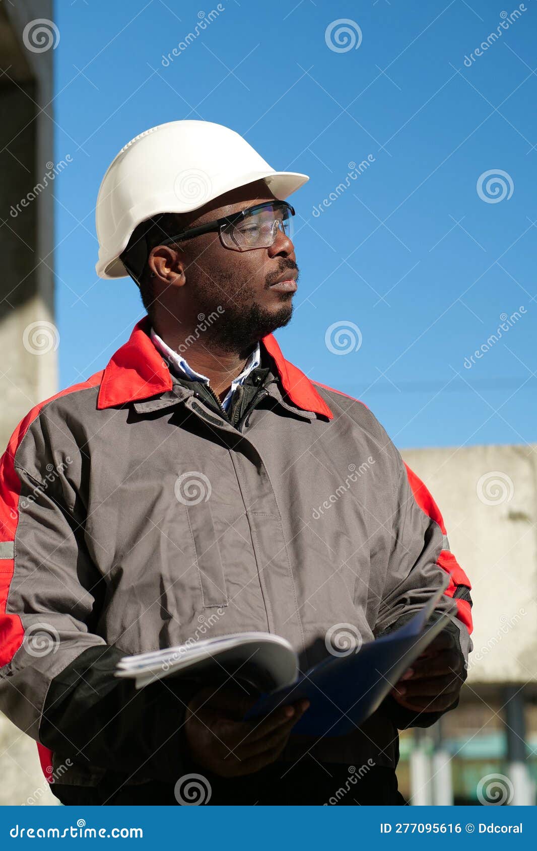 African American Worker Stands at Construction Site with Work Papers ...