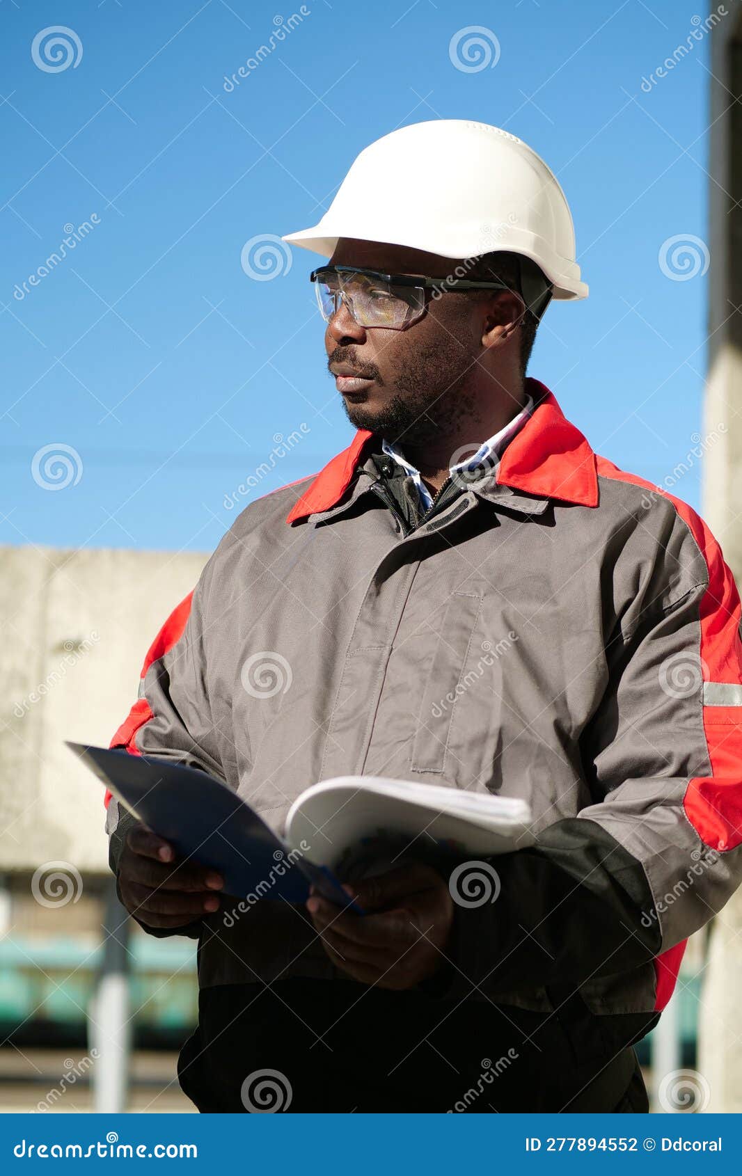 African American Worker Stands at Construction Site with Work Papers ...