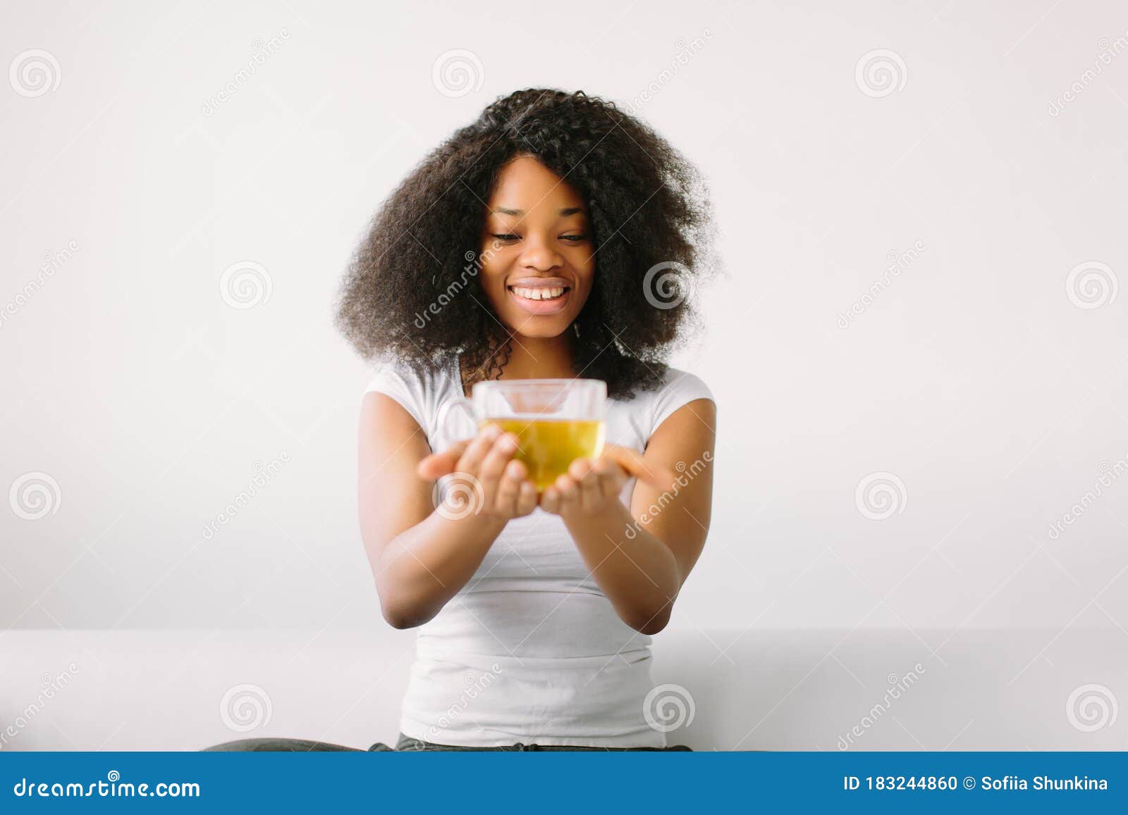 An African American Young Woman Sitting In The Lotus Position On White