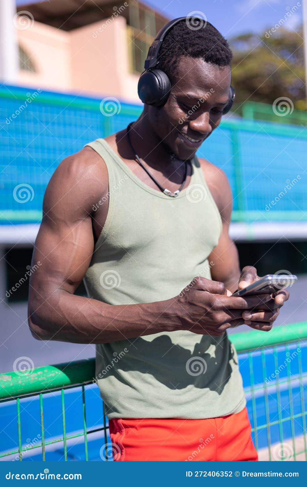 African Athlete Looking at His Cell Phone on the Athletics Track Stock ...