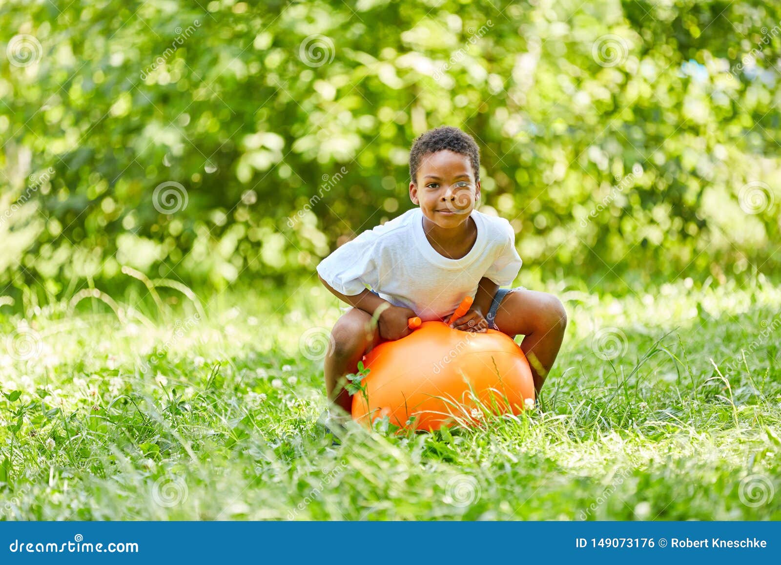 African Boy is Sitting on a Bouncing Ball Stock Photo - Image of ...