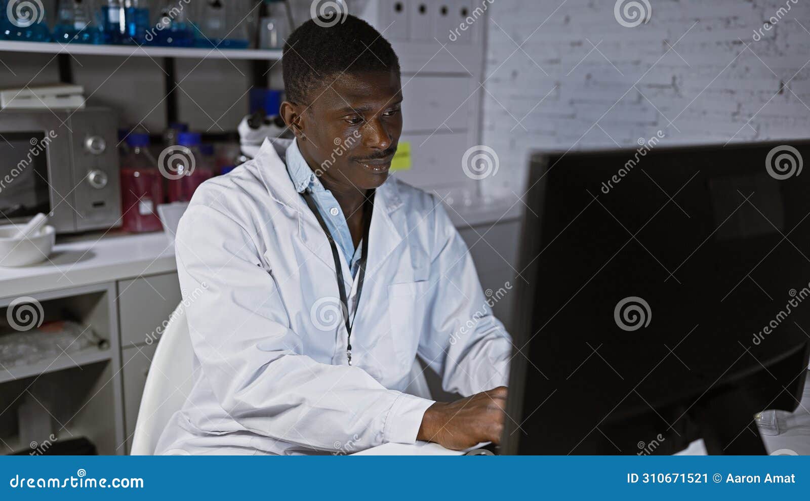 African Man in Lab Coat Working on Computer in a Modern Laboratory ...