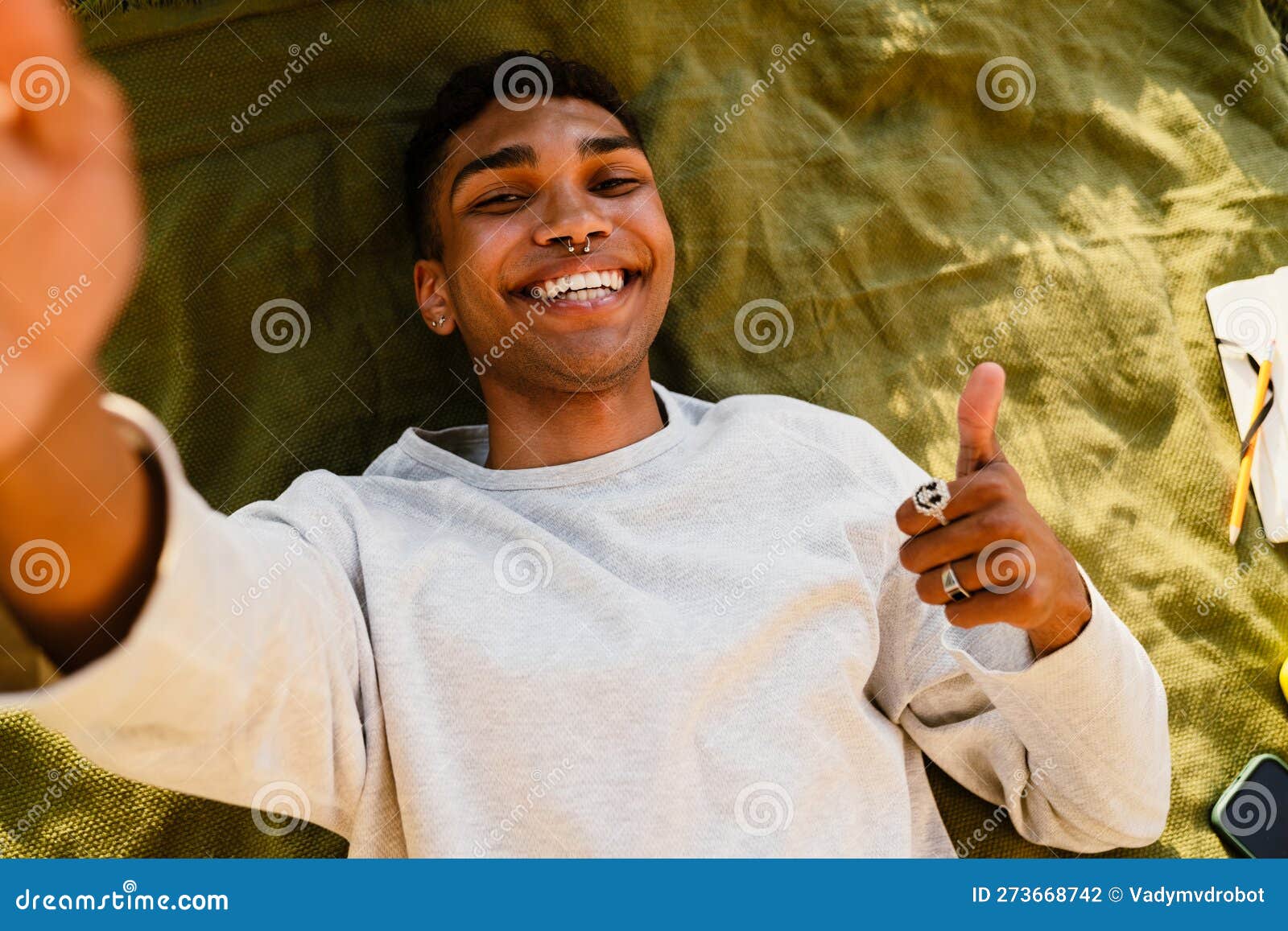 African Man Showing Thumbs Up While Taking Selfie On Phone In Sunny