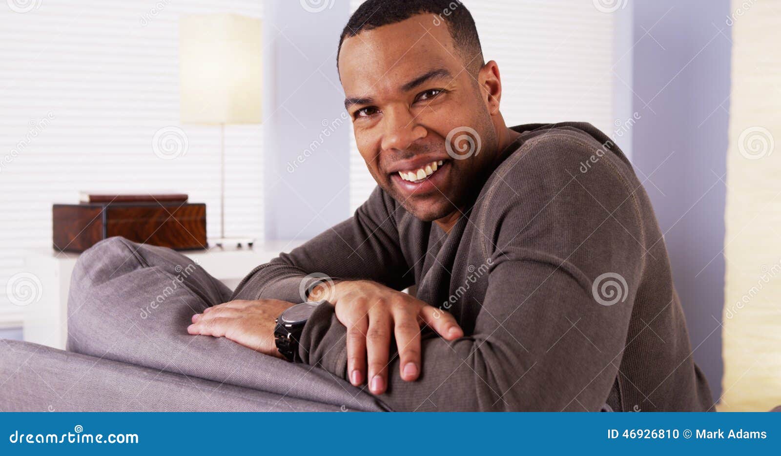 African Man Sitting on Couch Smiling Stock Photo - Image of person ...