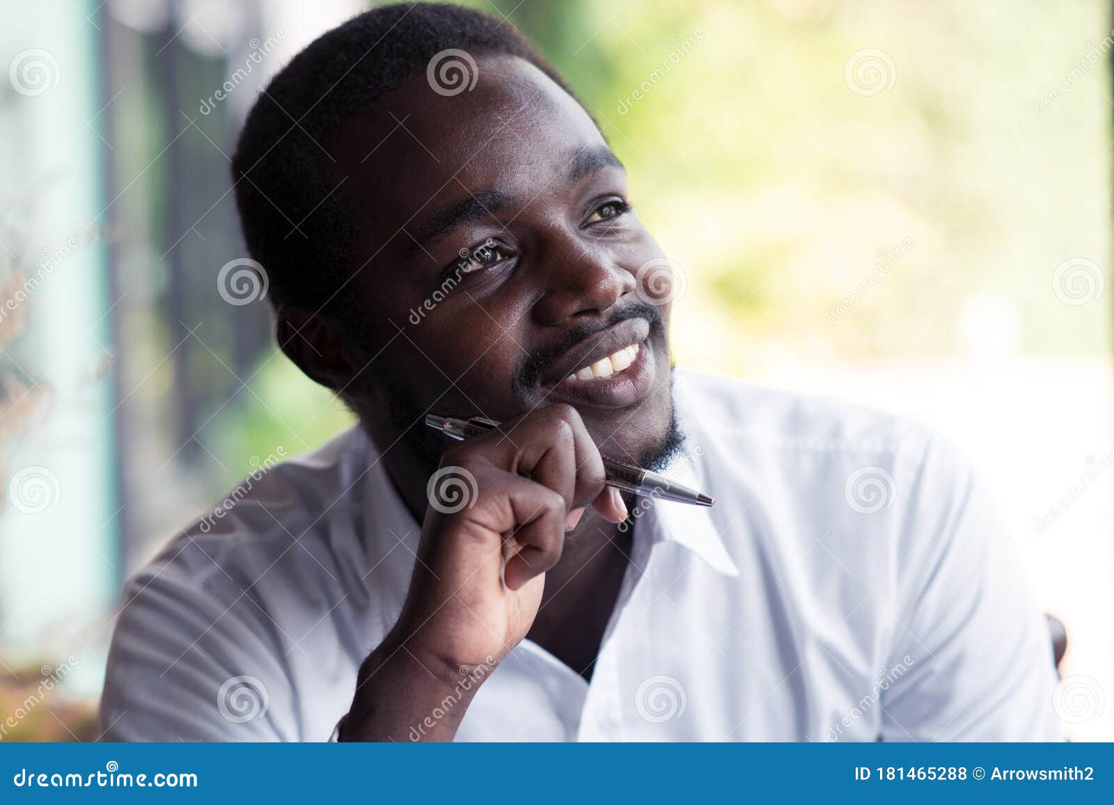 African Man Thinking and Looking with Holding a Pen Stock Photo - Image ...