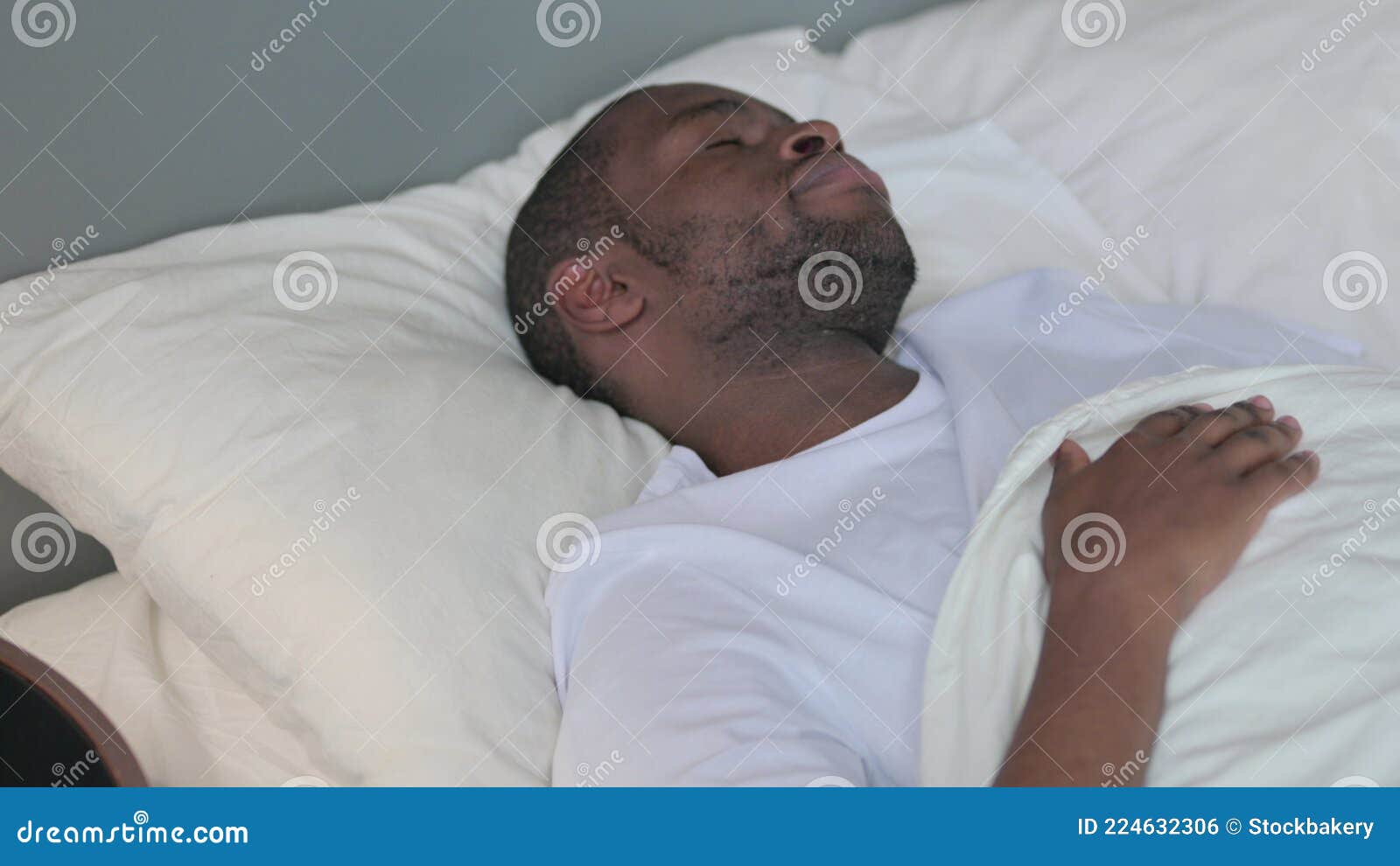 Young African Man Waking Up from Sleep in Bed Stock Photo - Image of ...