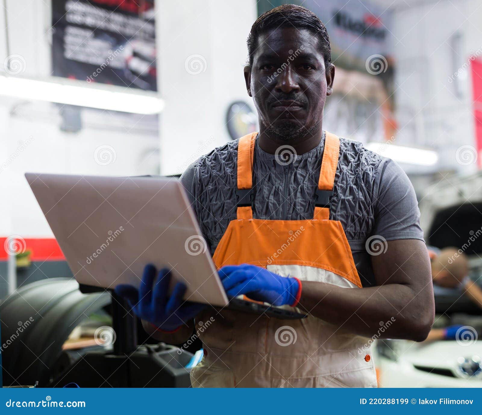 African Mechanic Man Using a Laptop Computer Checking Car in Workshop ...