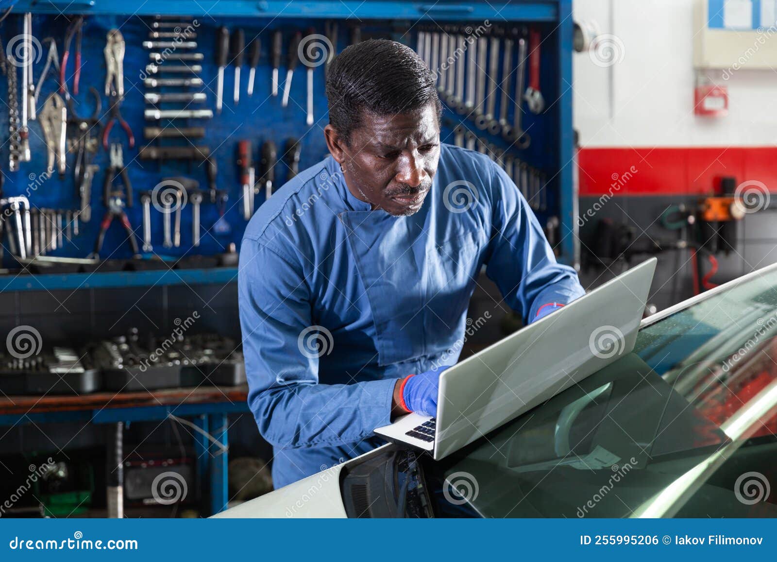 African Mechanic Man Using a Laptop Computer Checking Car in Workshop ...