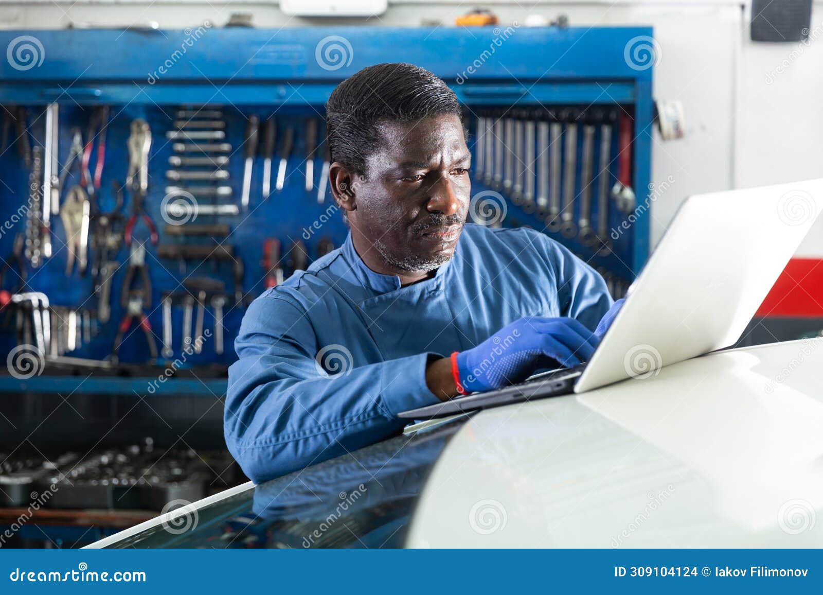 African Mechanic Man Using a Laptop Computer Checking Car in Workshop ...