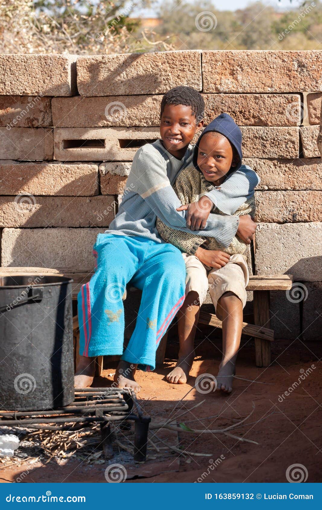 African Siblings in a Village Stock Photo - Image of bench, hugging ...