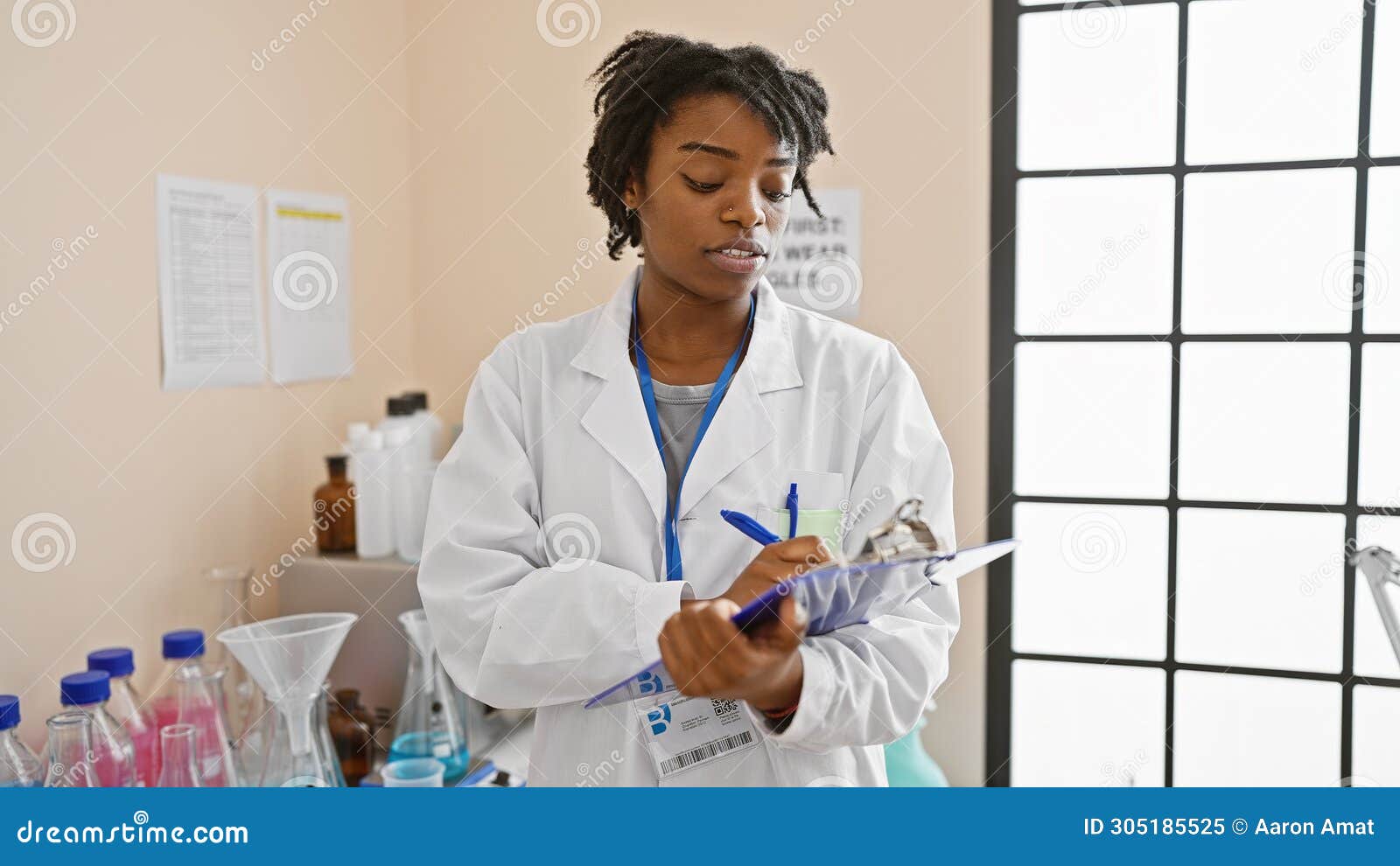 African Woman Scientist Writing Notes in a Laboratory Setting with ...